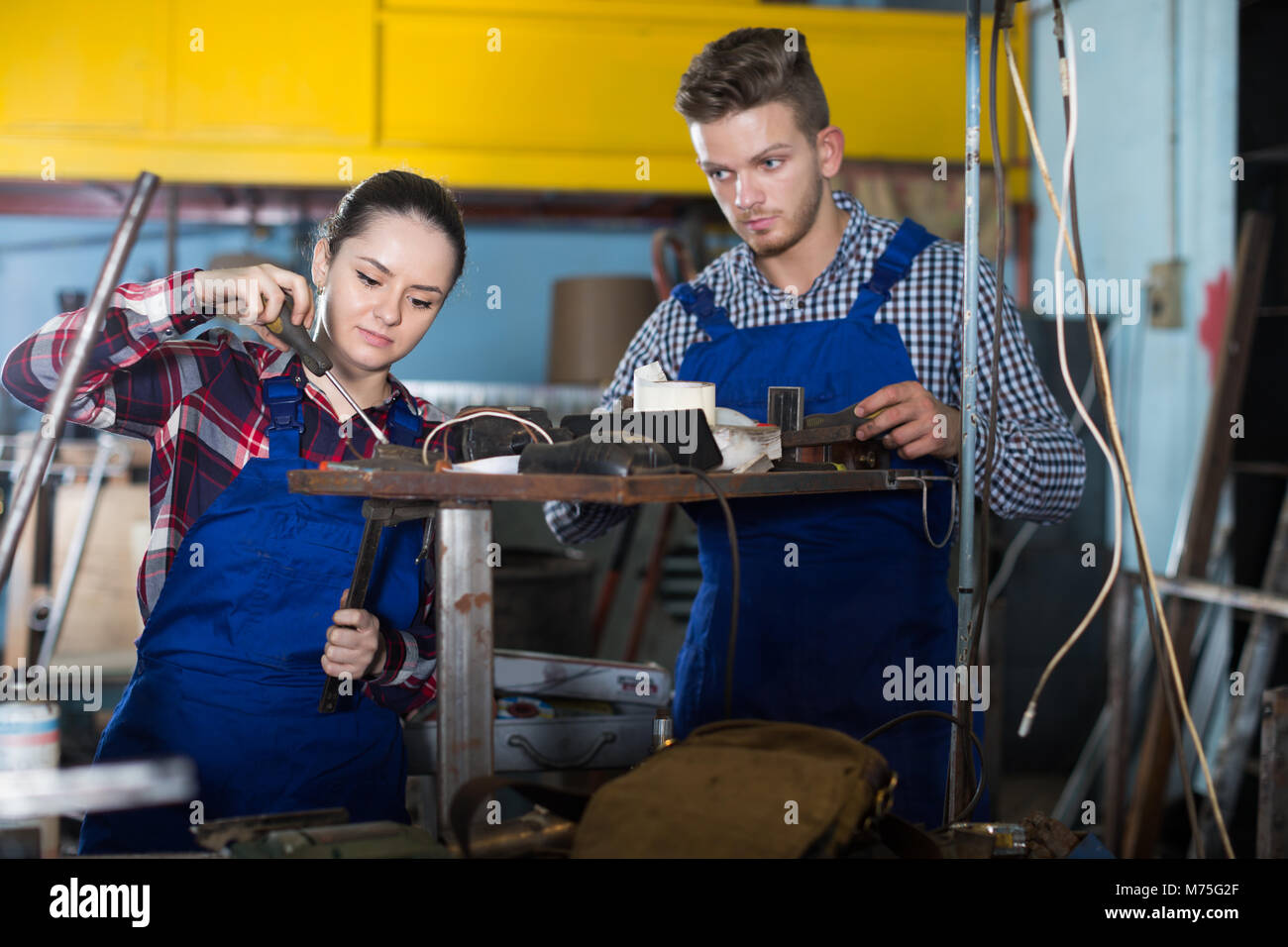 Portrait of masters who are working together near table in workshop ...