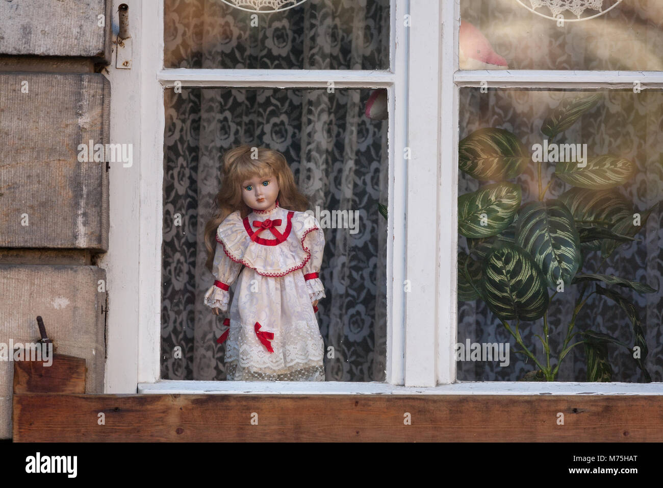 old-fashioned dressed puppet behind window pane of old building Stock ...