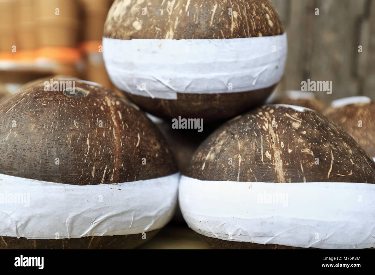 Bunch of smooth shelled-non coired coconuts with white plastic adhesive ...