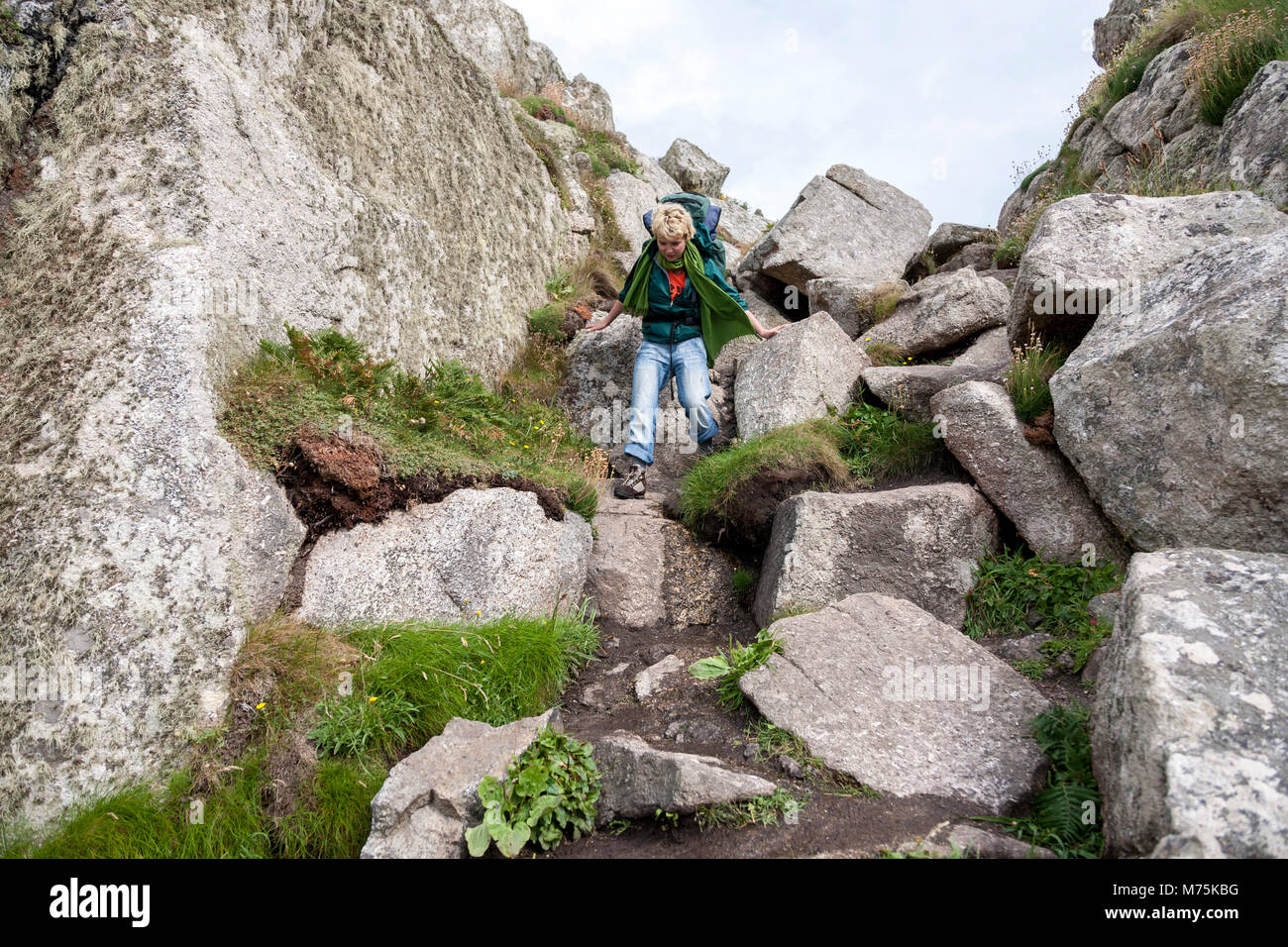 A backpacker on her way in Cornwall hills on the coast by the Celtic ...