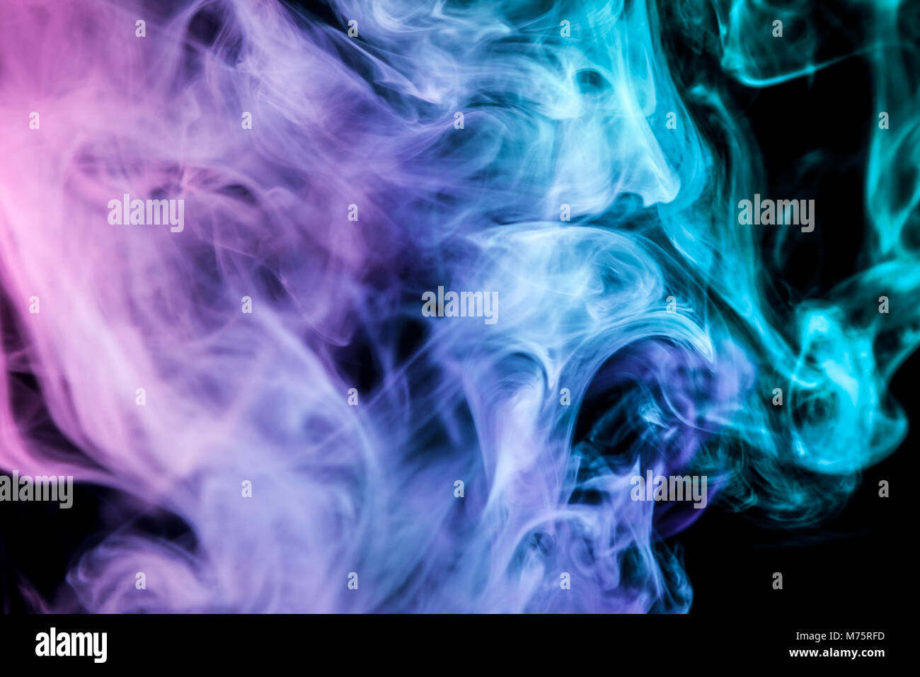 Thick colorful smoke of blue and purple on a black isolated background ...