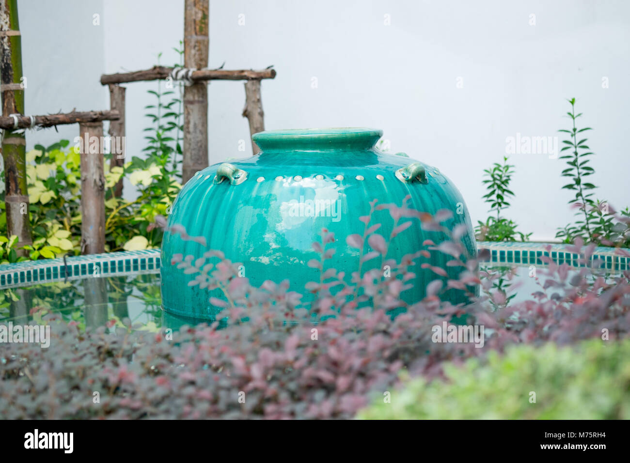 Green bowl fountain and pool in small garden Stock Photo - Alamy