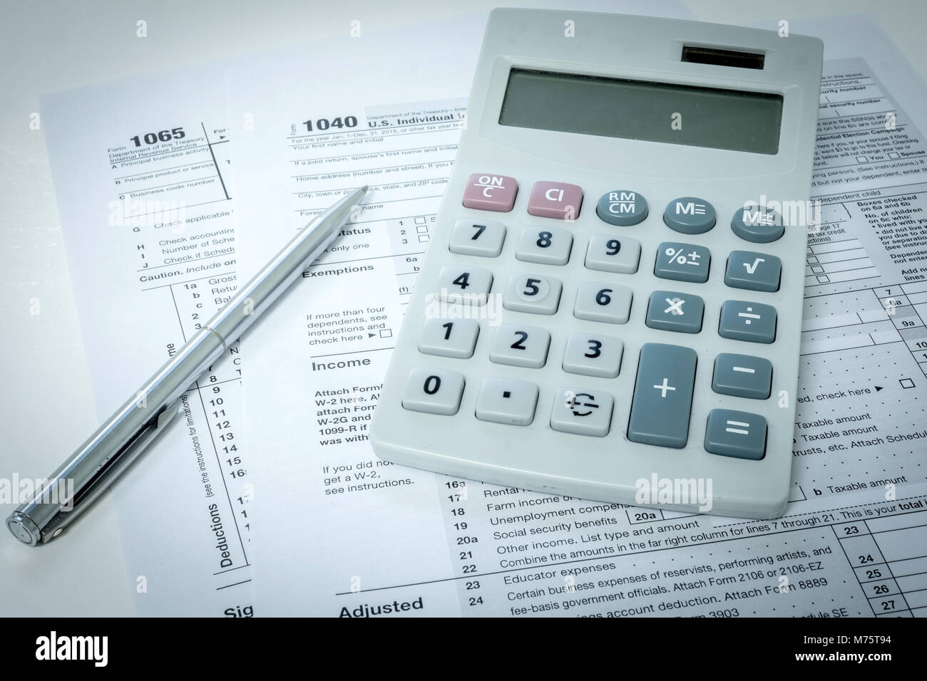 US tax form 1040 and 1065 with a pen and calculator Stock Photo - Alamy
