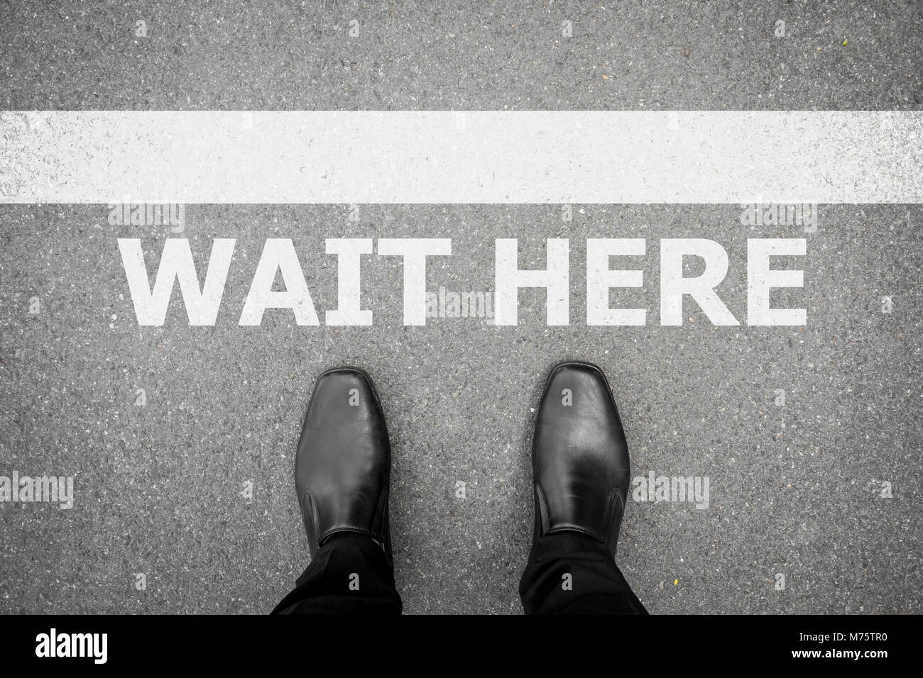 black shoes standing at wait here line on the asphalt concrete floor ...