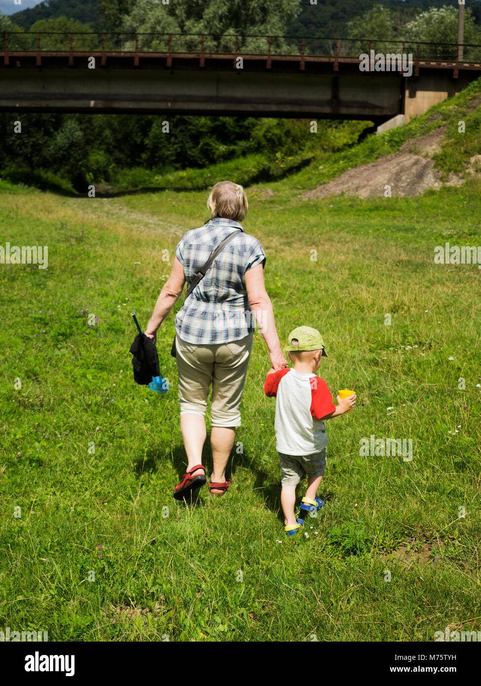 Grandma is walking with her grandchildren on the lawn Stock Photo - Alamy