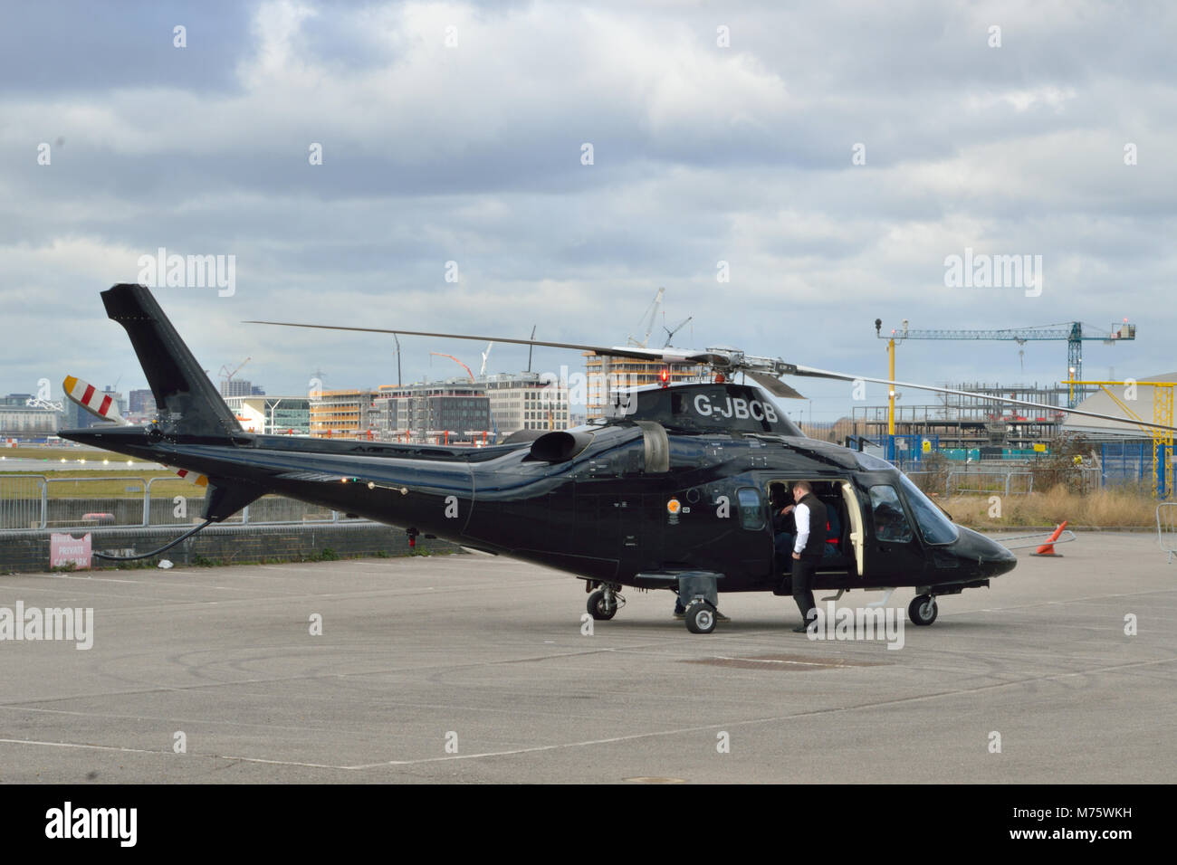 Castle Air Augusta A109 helicopter on the ground in a car park adjacent to London City Airport ...