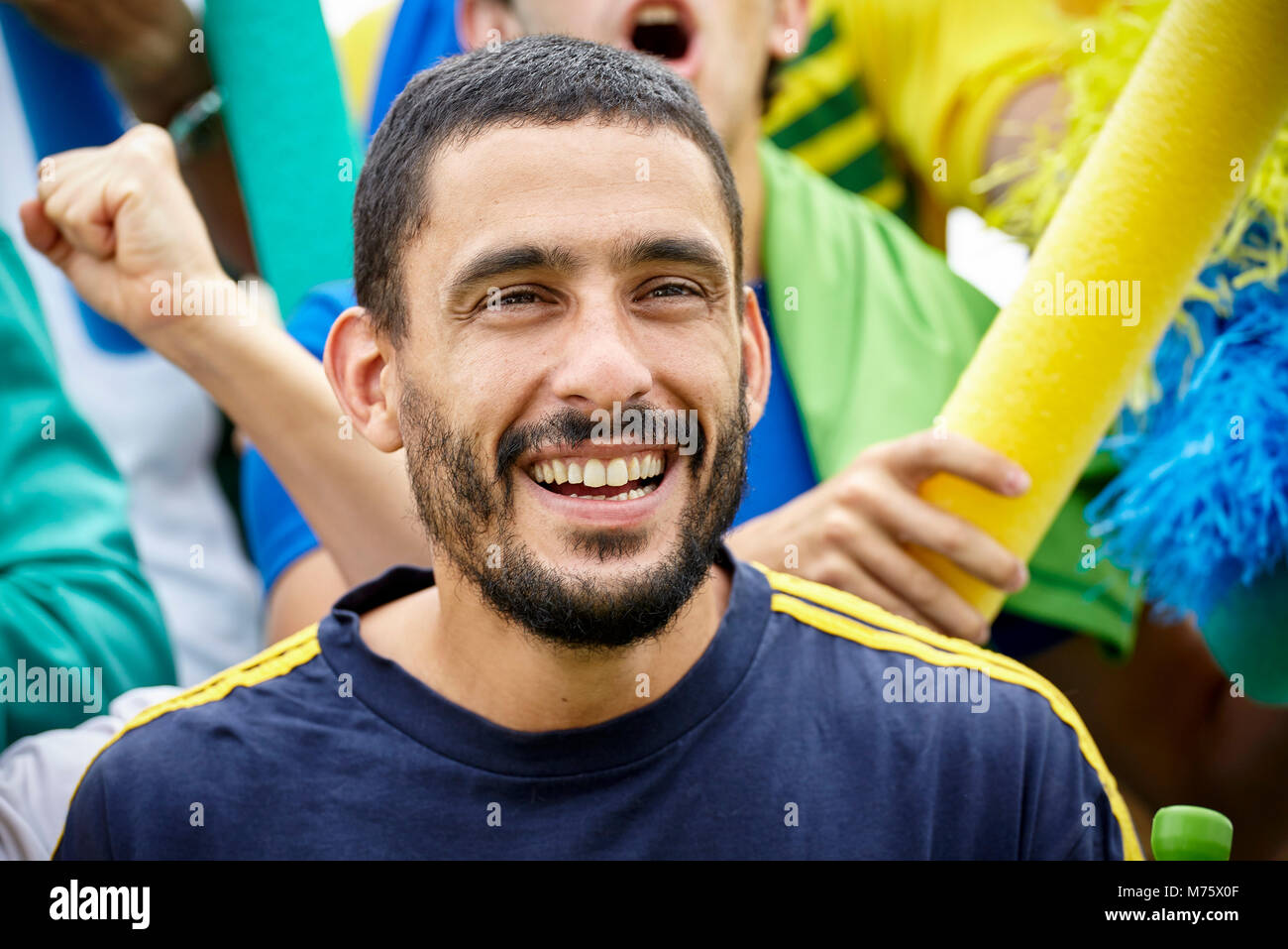 Man smiling cheerfully at football match, portrait Stock Photo - Alamy