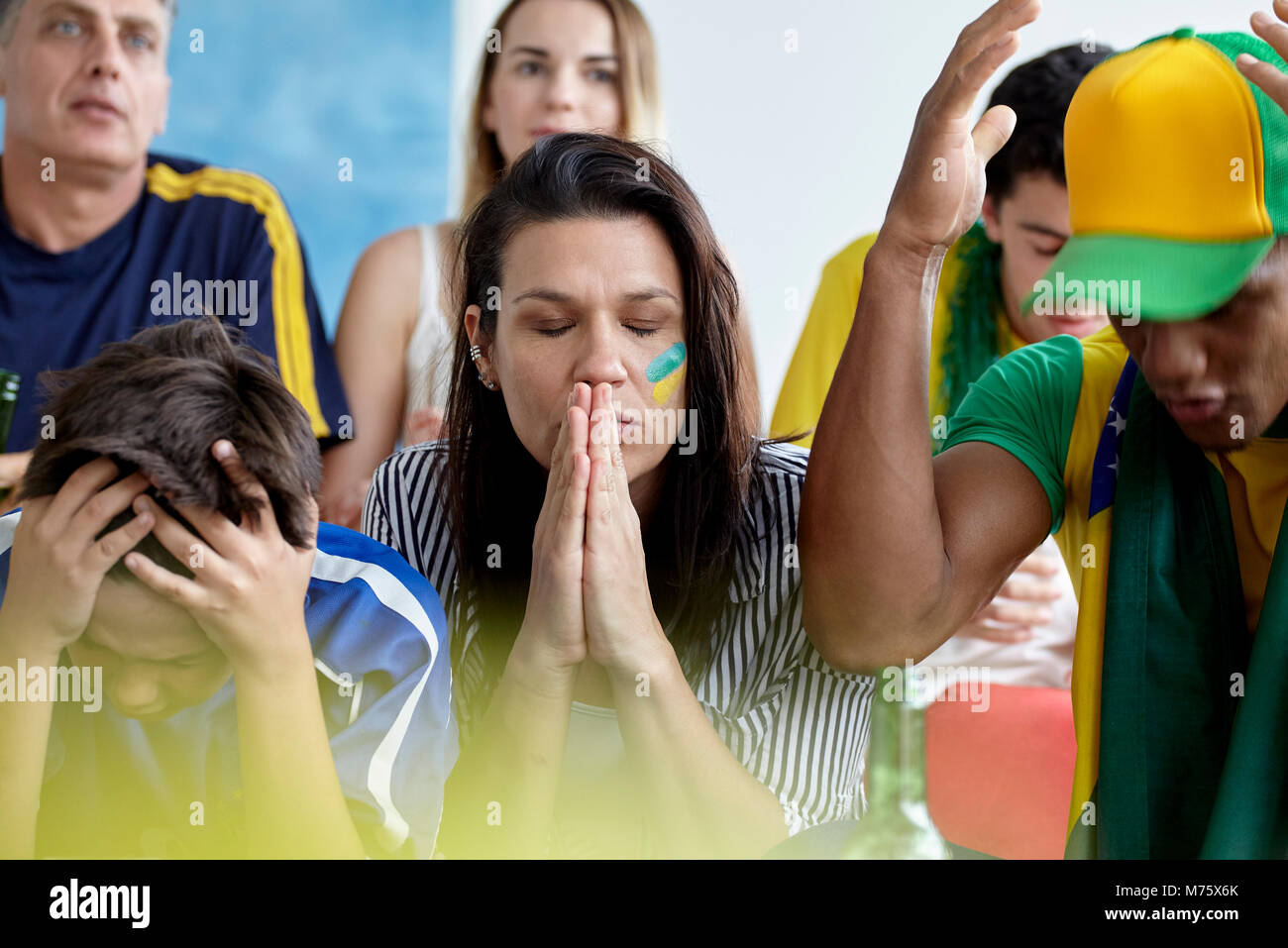 Brazilian football fans looking upset while watching match at home ...