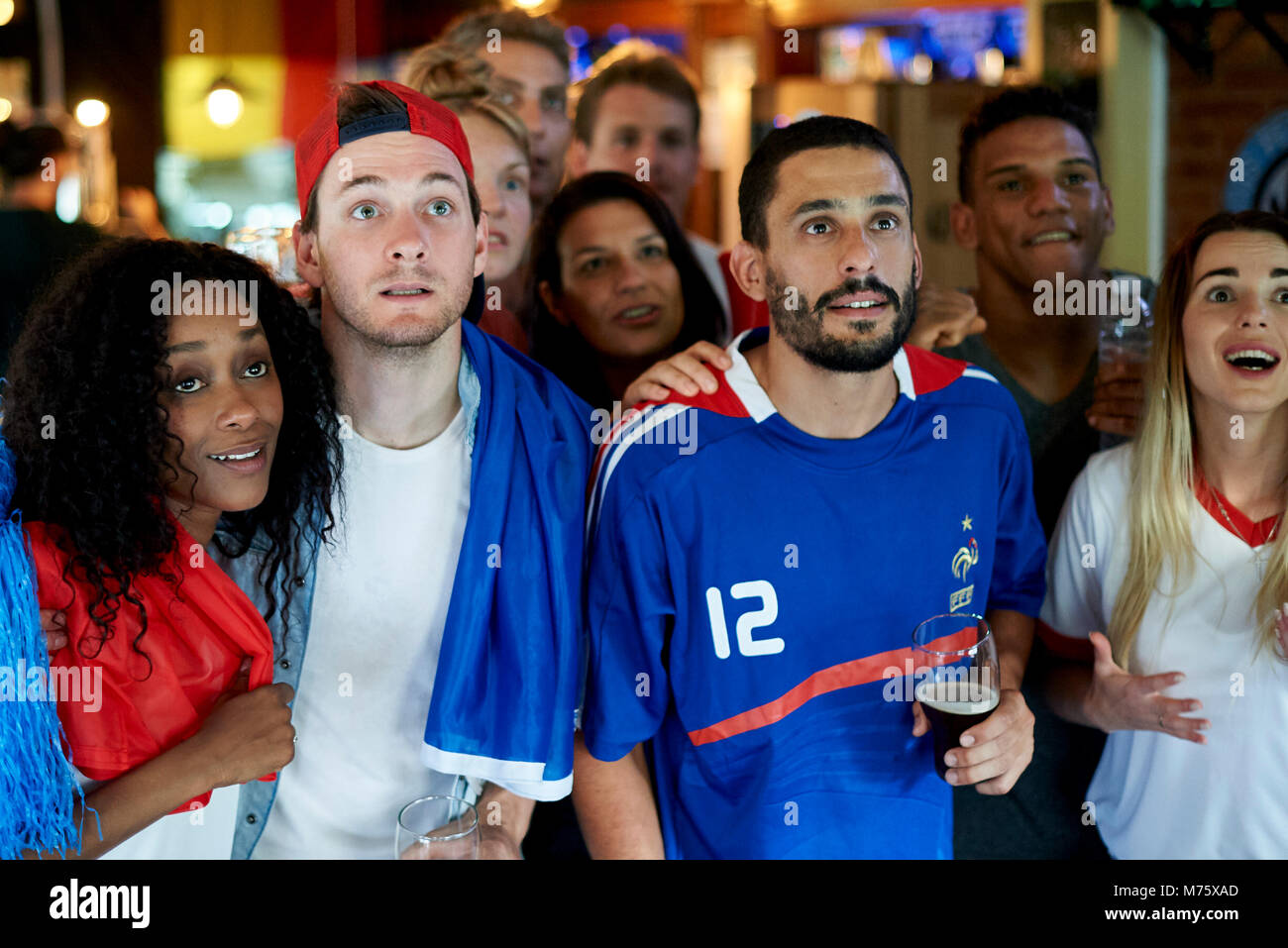 French football fans watching soccer match on television at pub Stock ...