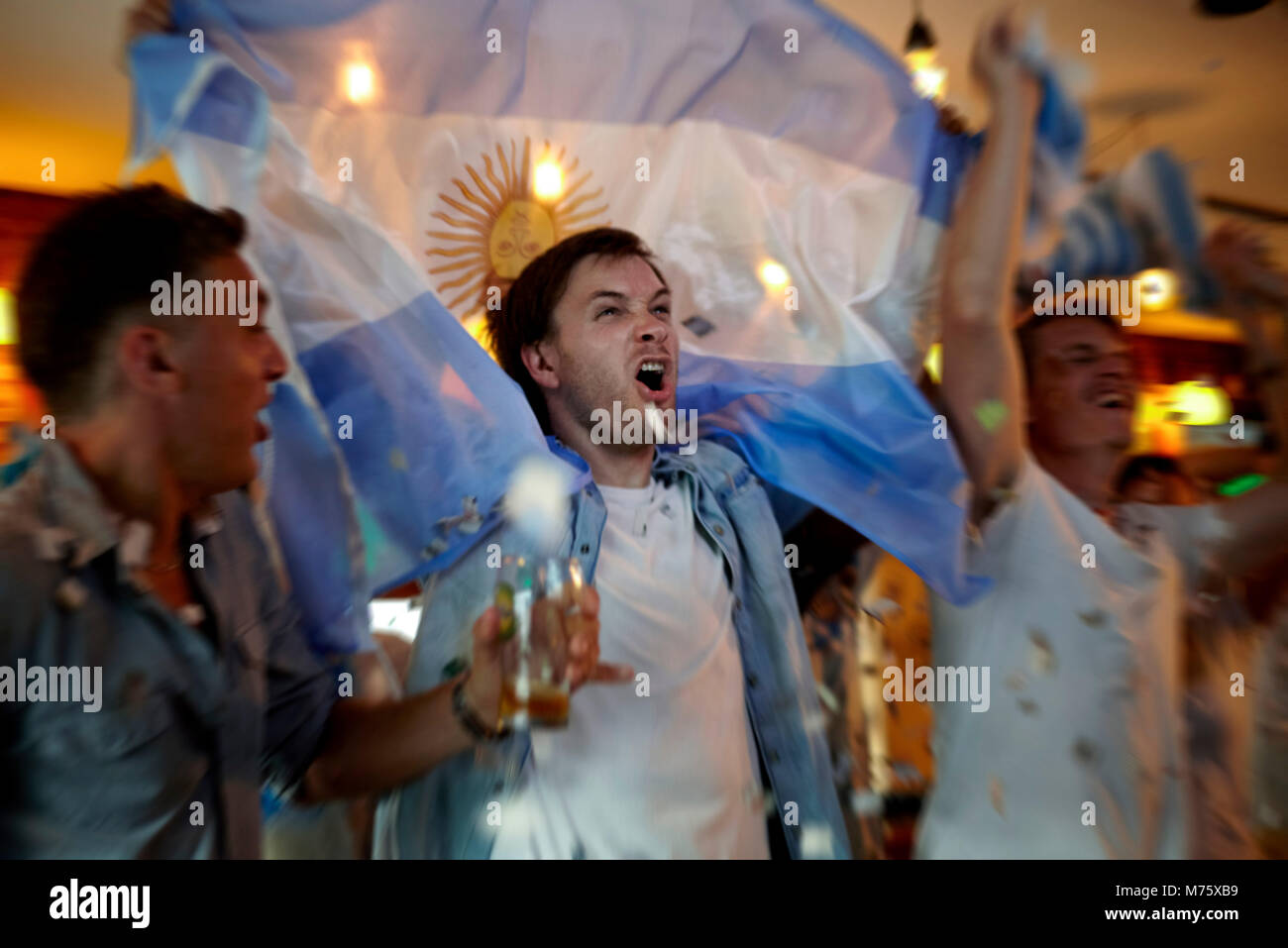 Argentinian football fans celebrating in bar Stock Photo - Alamy
