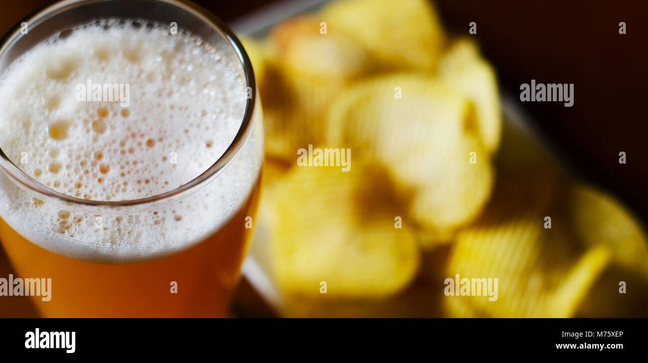 pint of lager beer in a glass, set of various snacks, a standard set of ...