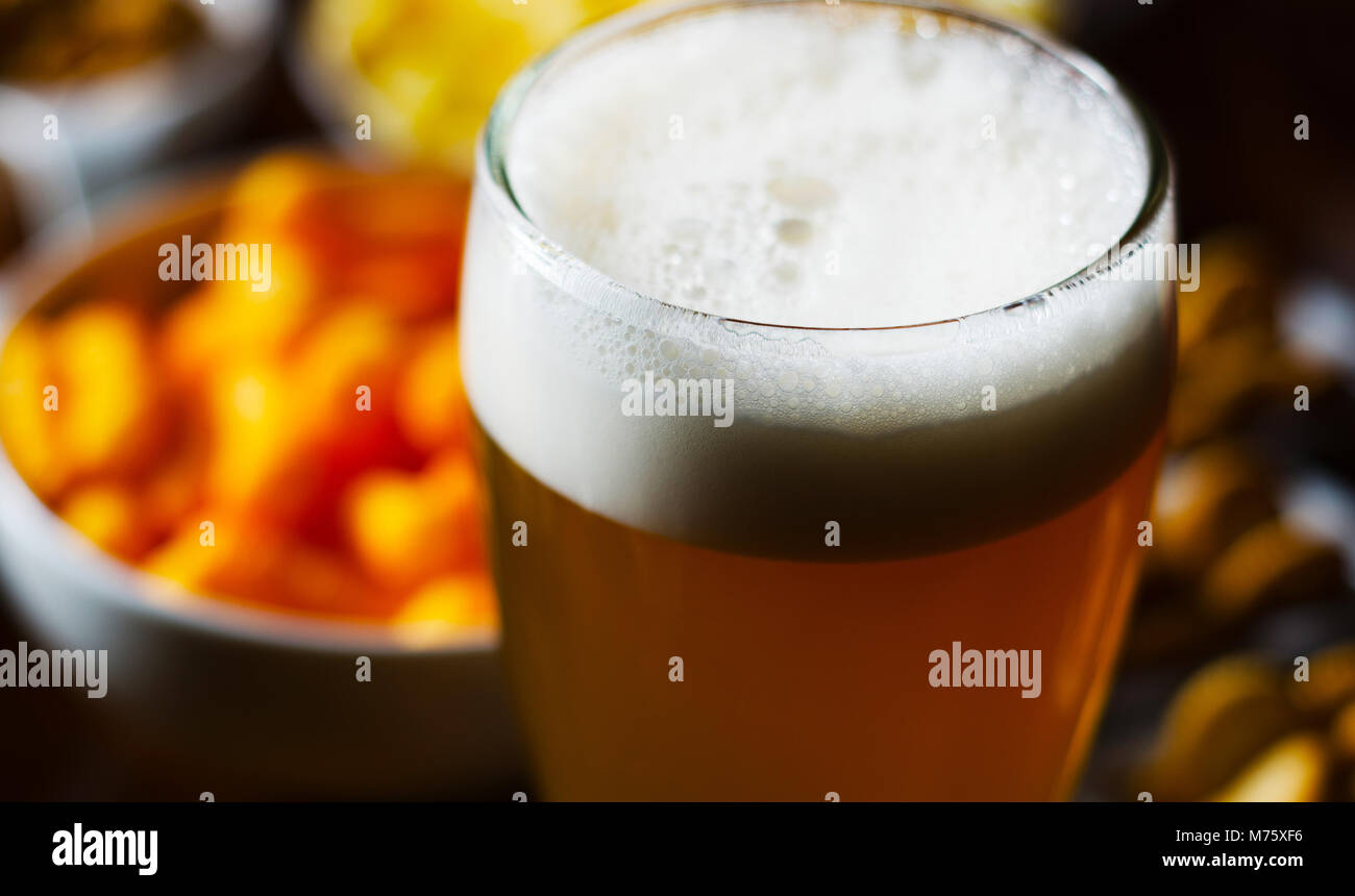 pint of lager beer in a glass, set of various snacks, a standard set of ...
