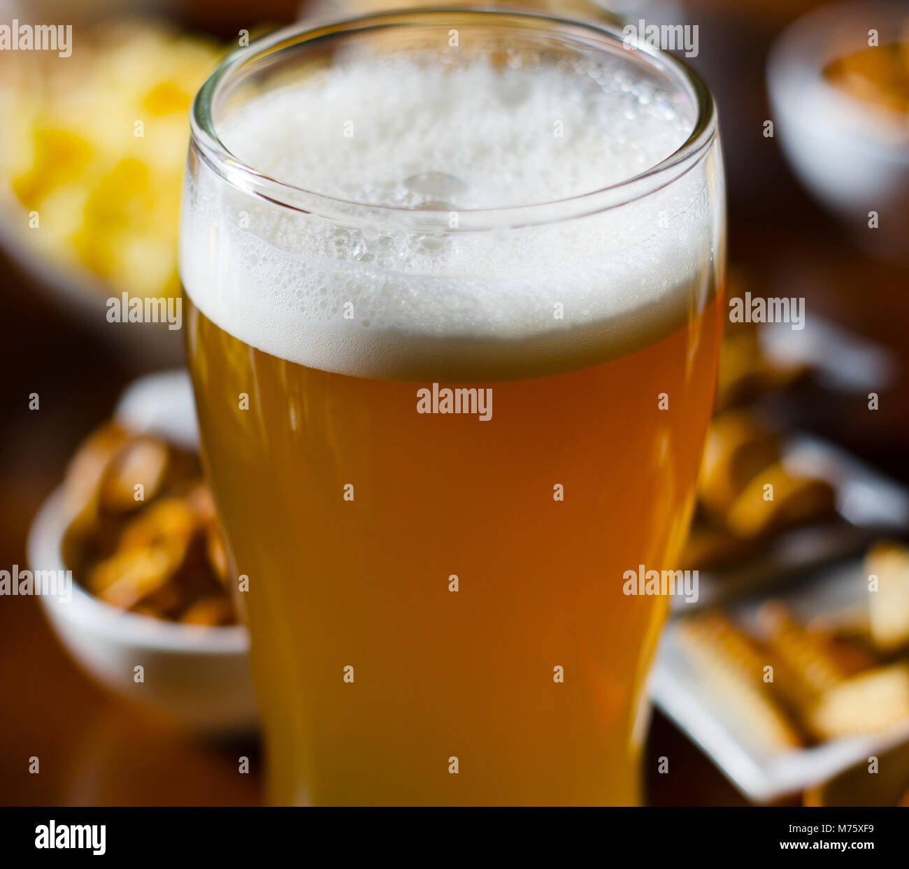 pint of lager beer in a glass, set of various snacks, a standard set of ...