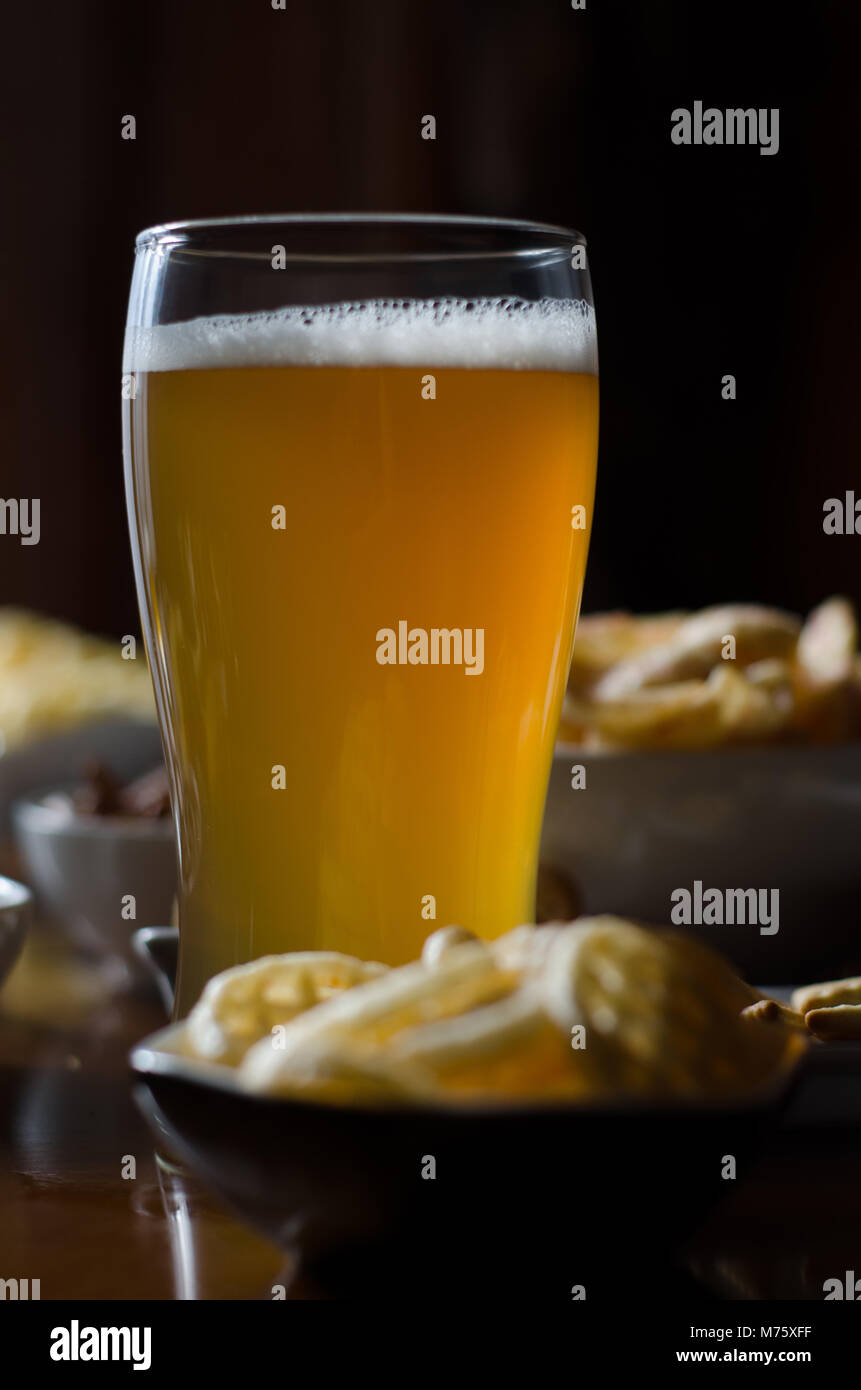 pint of lager beer in a glass, set of various snacks, a standard set of ...