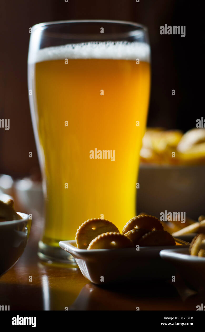 pint of lager beer in a glass, set of various snacks, a standard set of ...