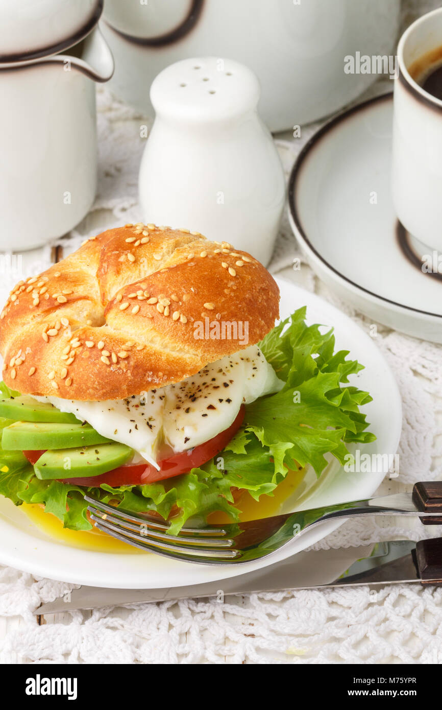 A Traditional Breakfast. Bun with sesame seeds, poached egg, avocado ...