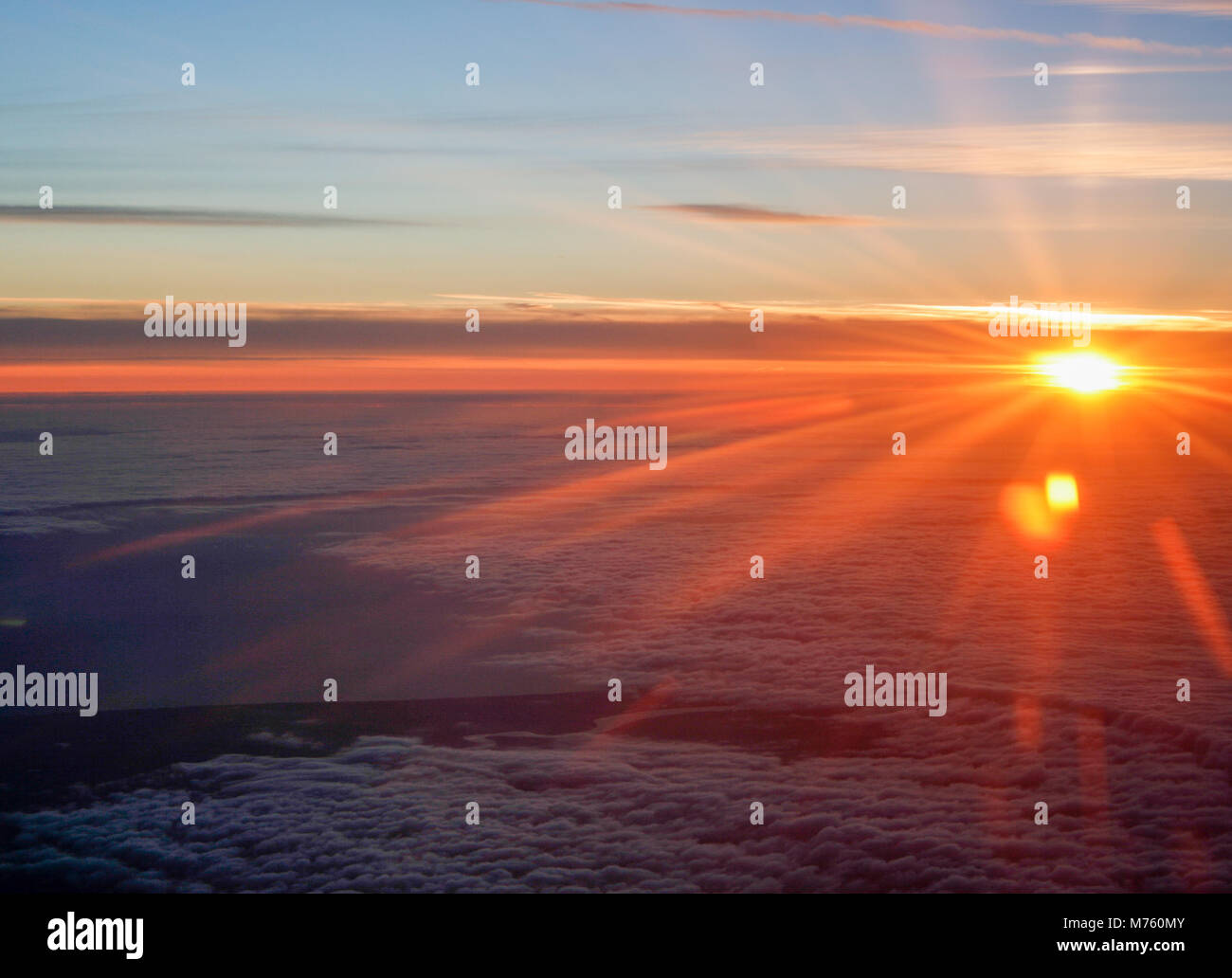 Aerial view of a glorious red sunset against a bright blue sky while ...