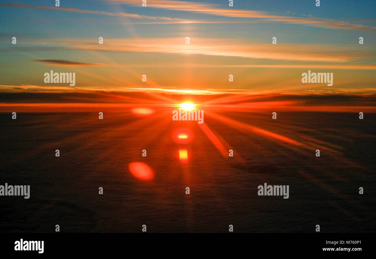 Aerial view of a glorious red sunset against a bright blue sky while ...