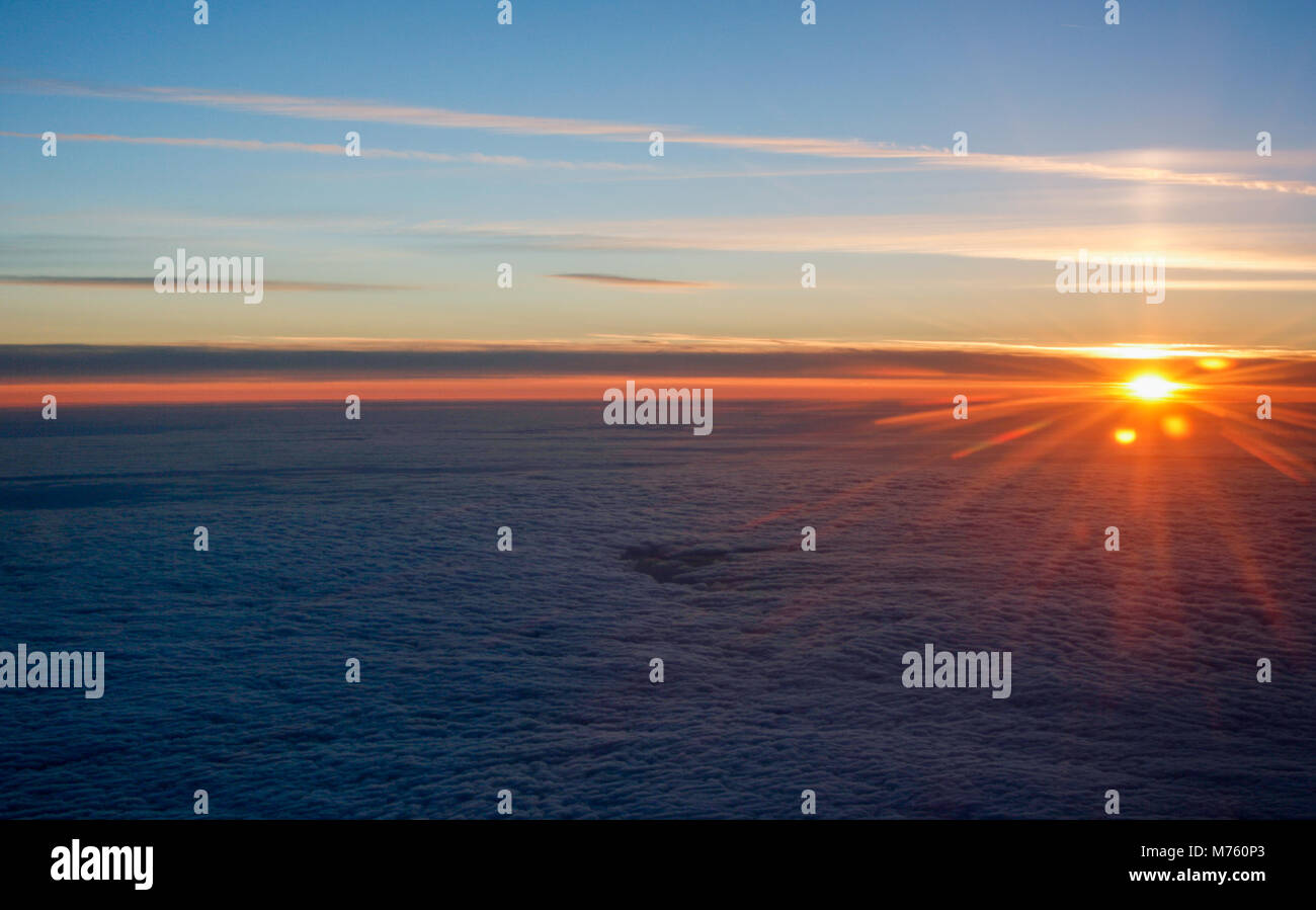 Aerial view of a glorious red sunset against a bright blue sky while ...