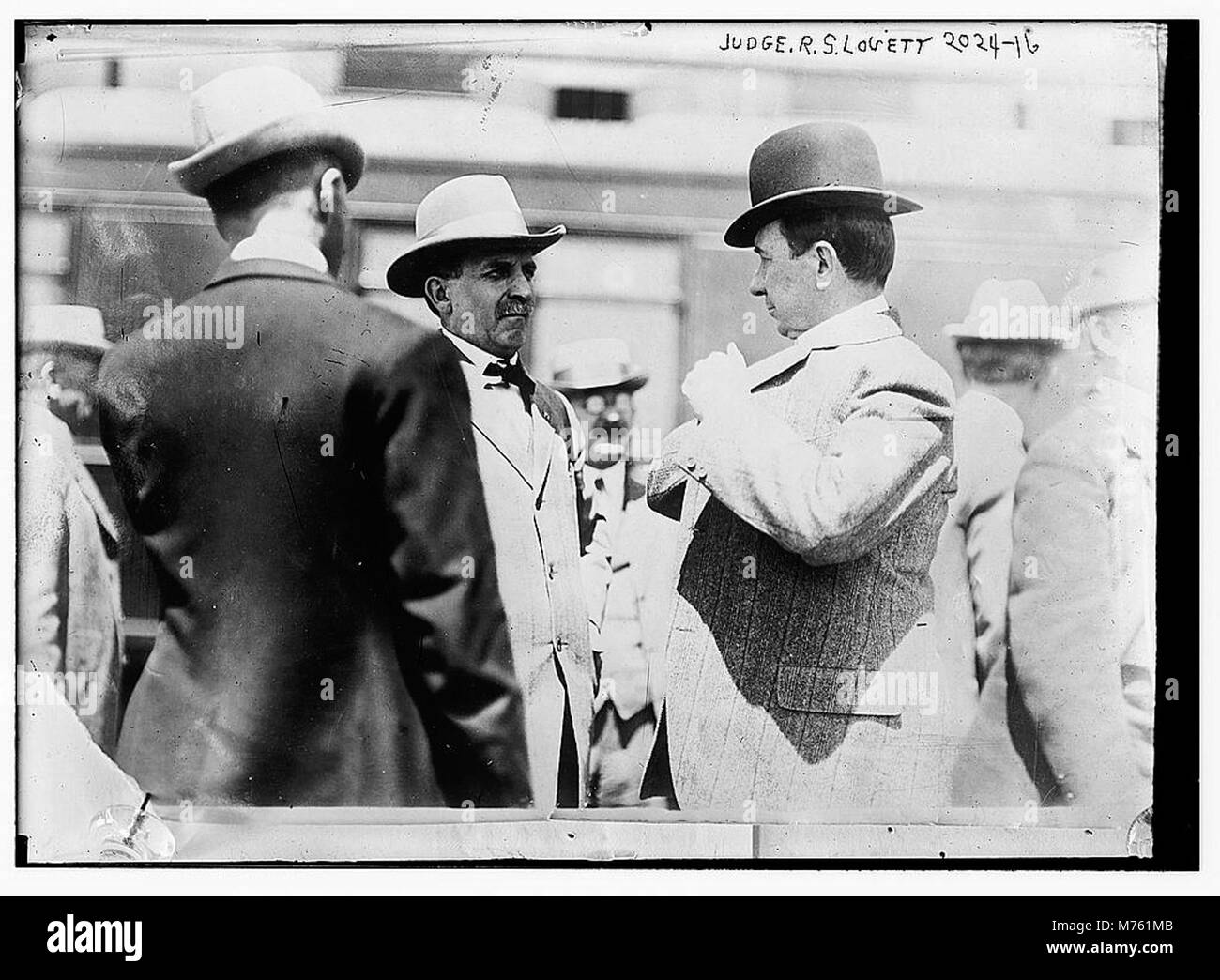 This image shows Judge R.S. Louett, posed with two men in front of a ...