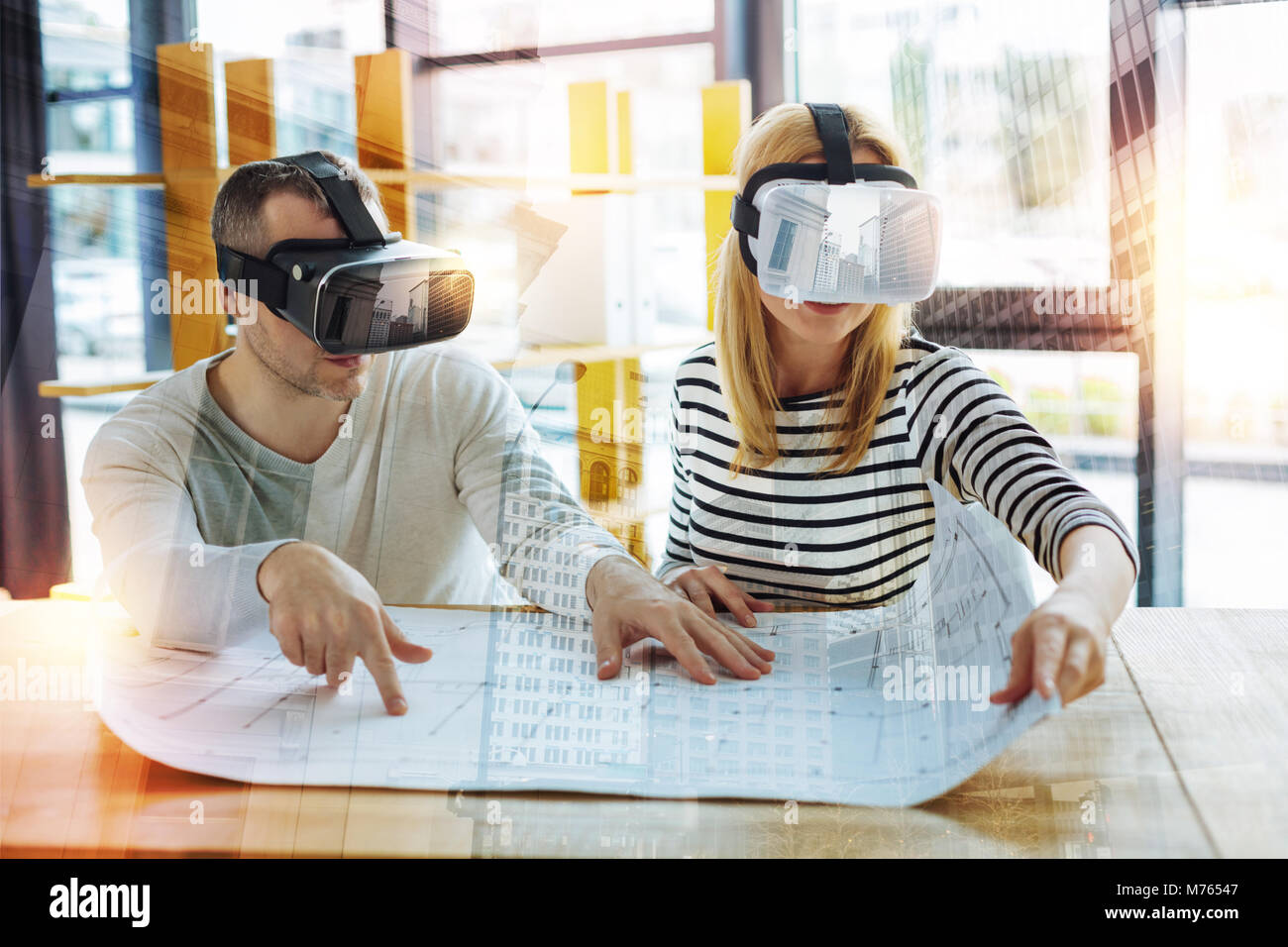 Qualified engineers sitting at the table and working with a detailed ...