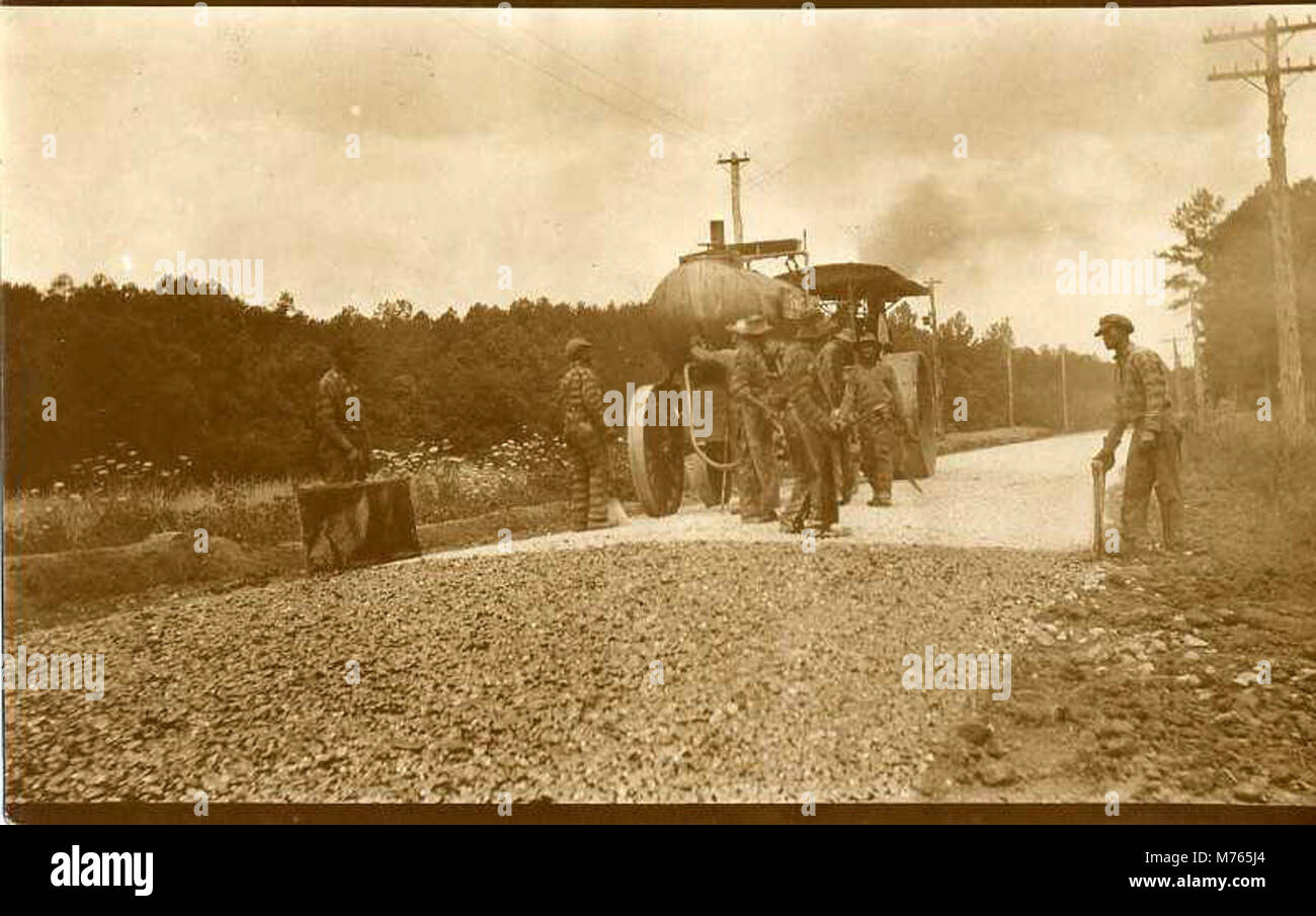 This historical photograph shows a road construction crew made up of ...
