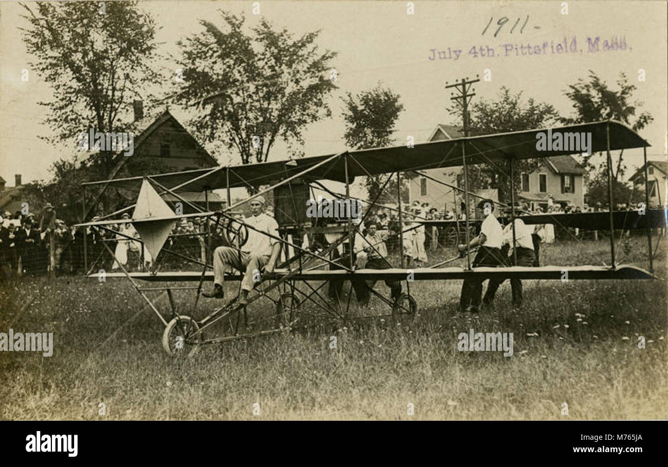 A sharp, full view of an aviator in a dual-wing airplane preparing for ...