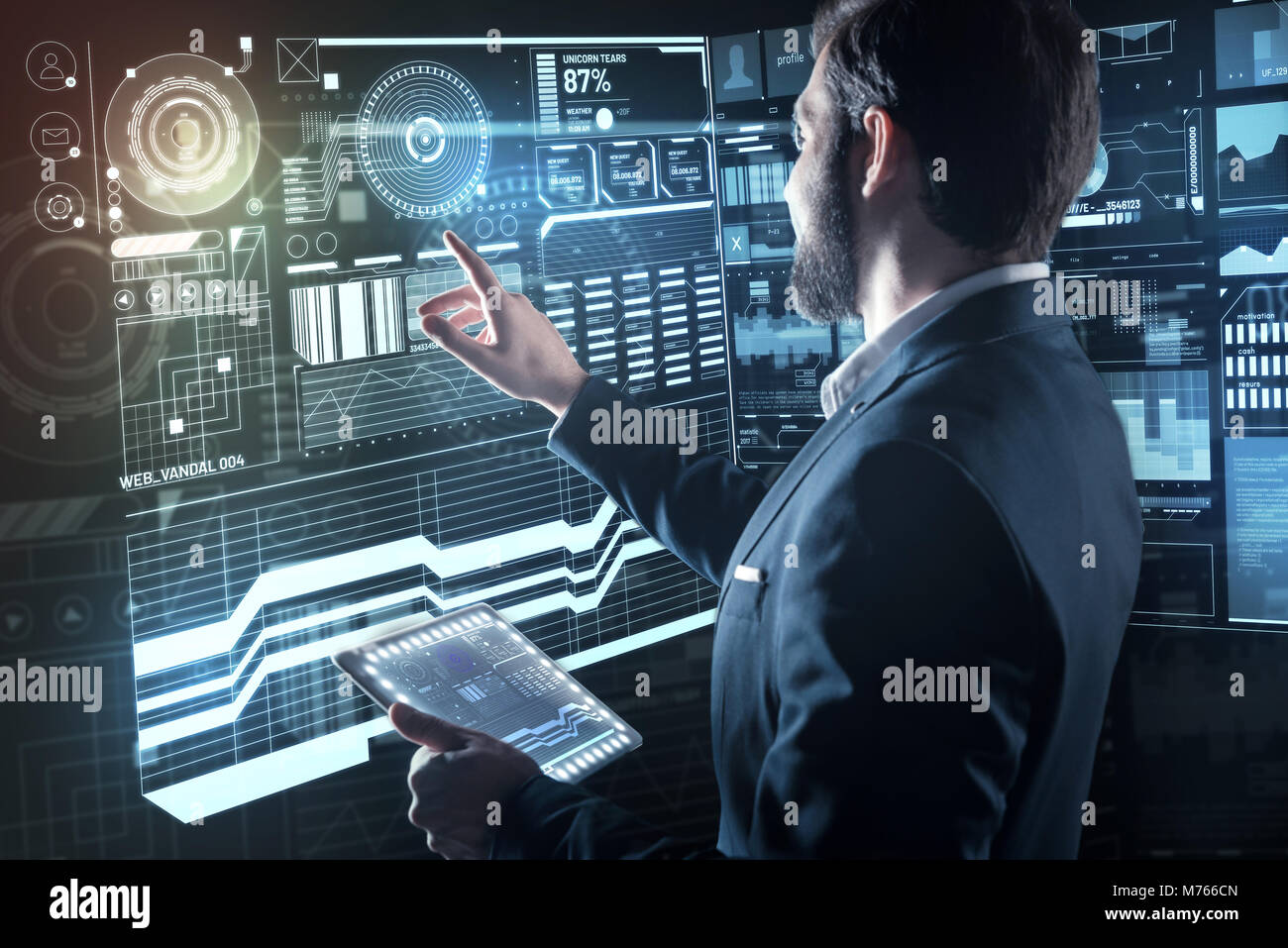 Smart programmer holding a tablet while working Stock Photo - Alamy