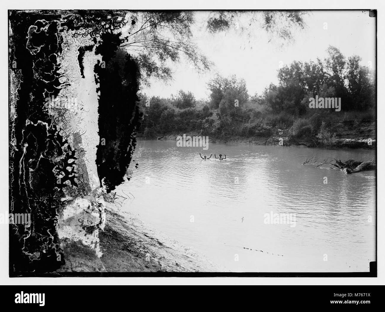 A photograph of a man and a woman swimming in the Jordan River. The ...