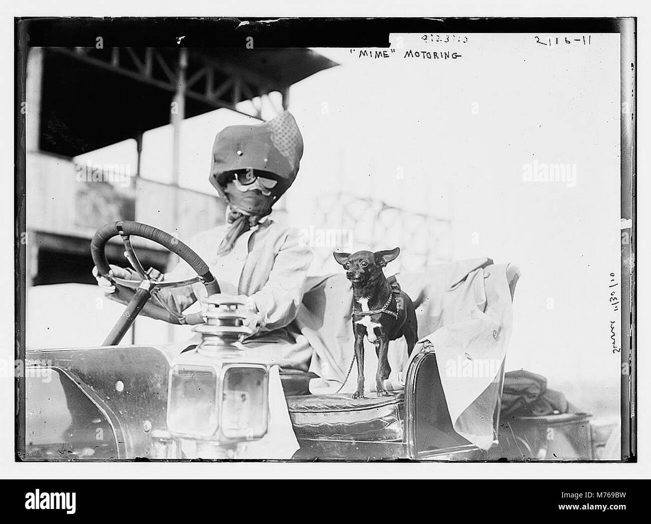 Photograph of a mime performing a motoring act. The image captures the ...