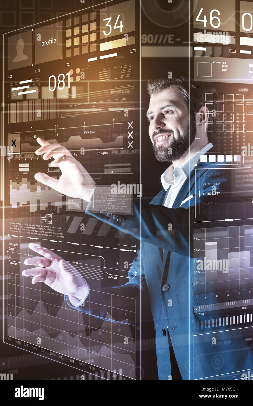 Positive elegant man smiling and touching a convenient transparent ...