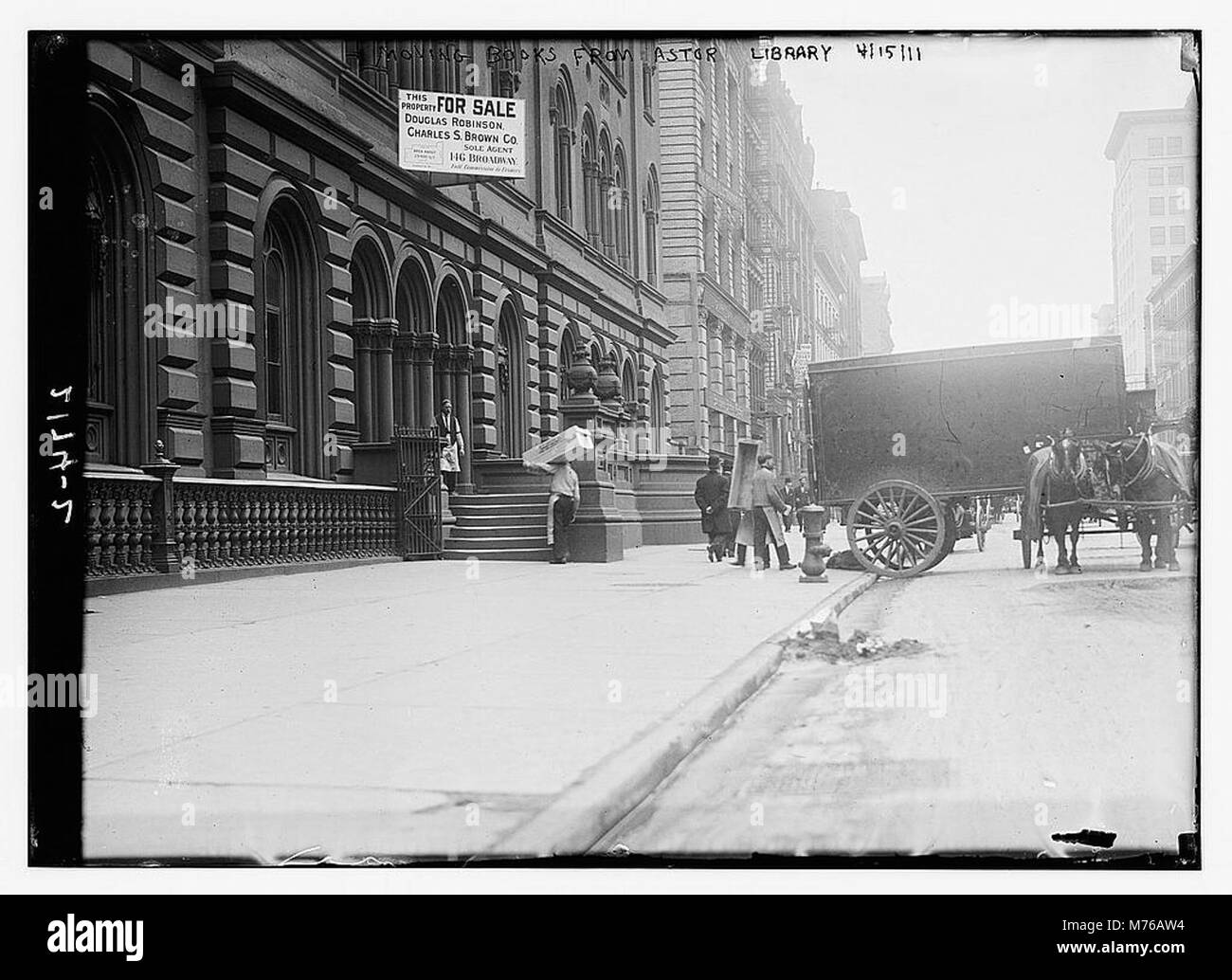 A photograph depicting the process of moving books from the Astor ...