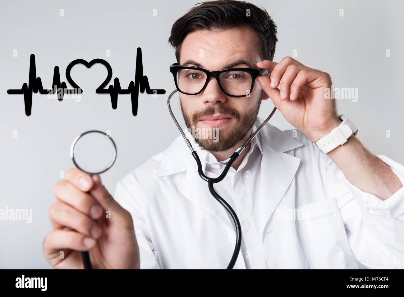 Smart cardiologist holding a stethoscope while examining his patient ...