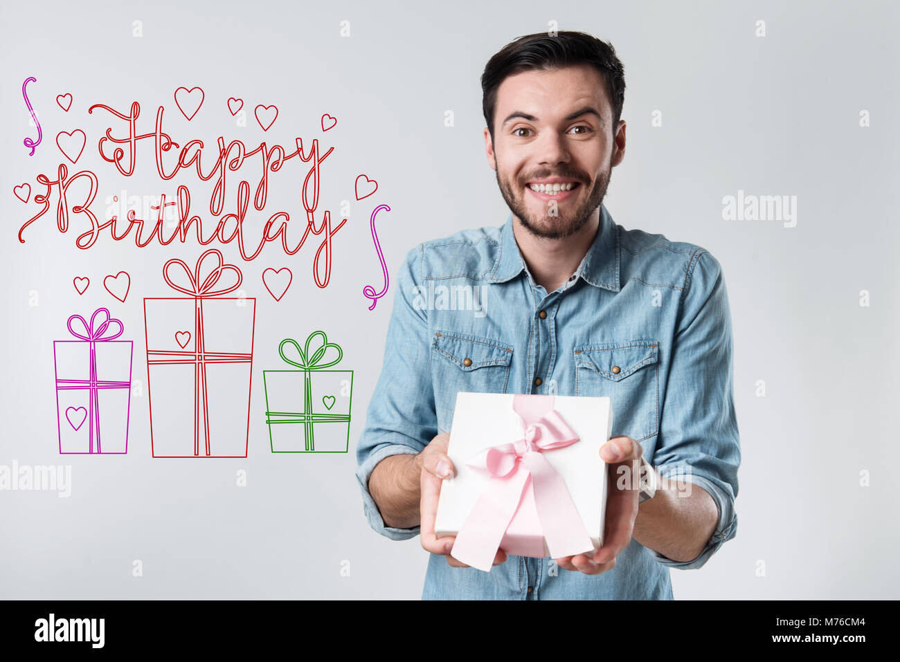 Emotional young man holding a present while being at the birthday party ...