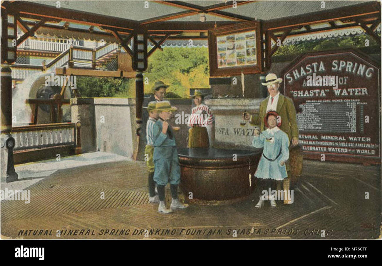 A natural mineral spring drinking fountain, with postcards framed above ...