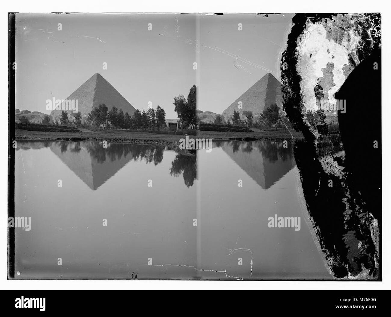 This photograph depicts the Nile River with the iconic pyramids of Giza ...