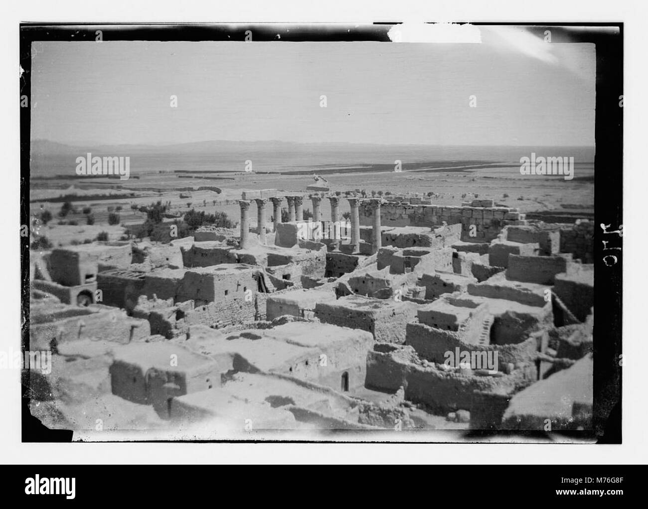 A photograph of a native village near the ruins of the Temple of the ...
