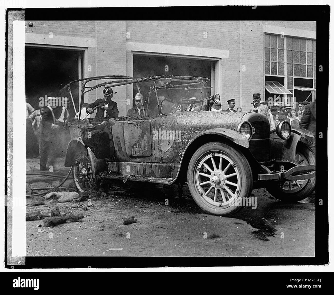 This photograph documents an auto fire incident, capturing the moment ...