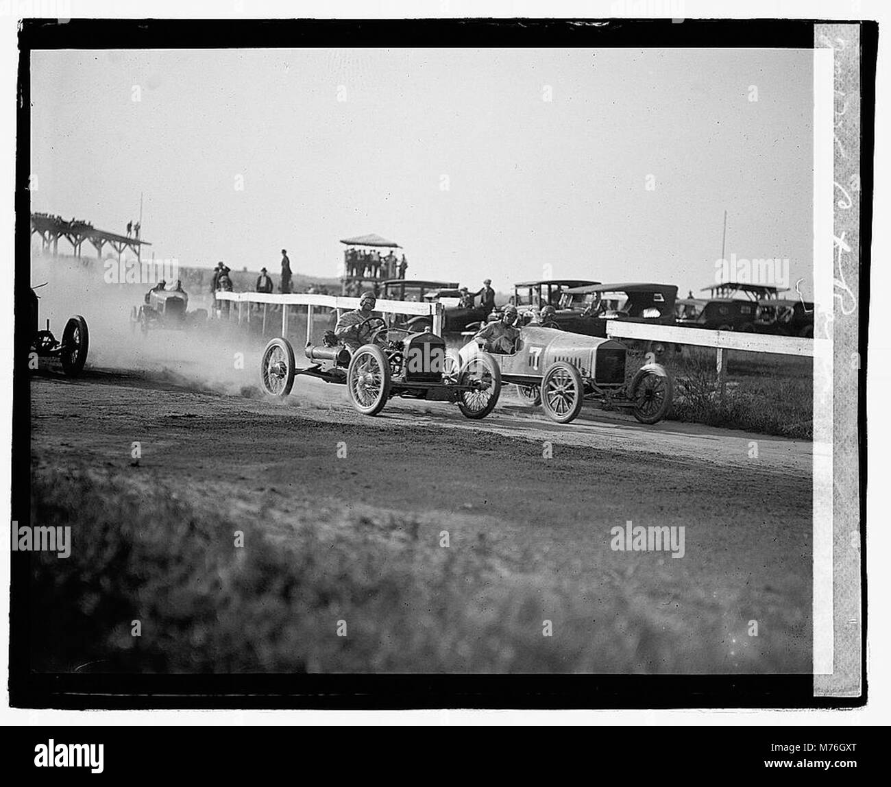This image captures a scene from an early auto race, highlighting the ...