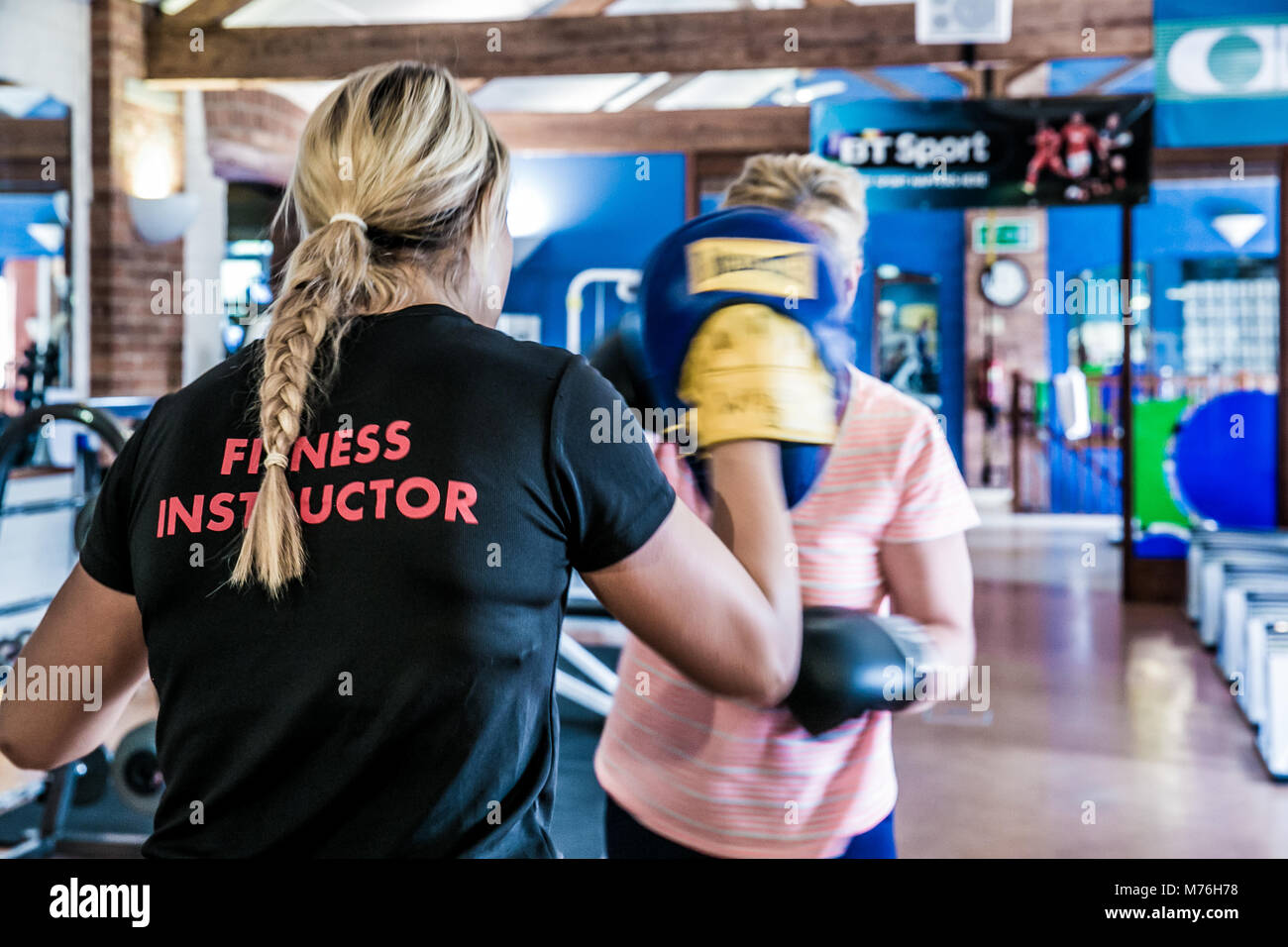 Female fitness instructor boxing with female client. in a one to one ...