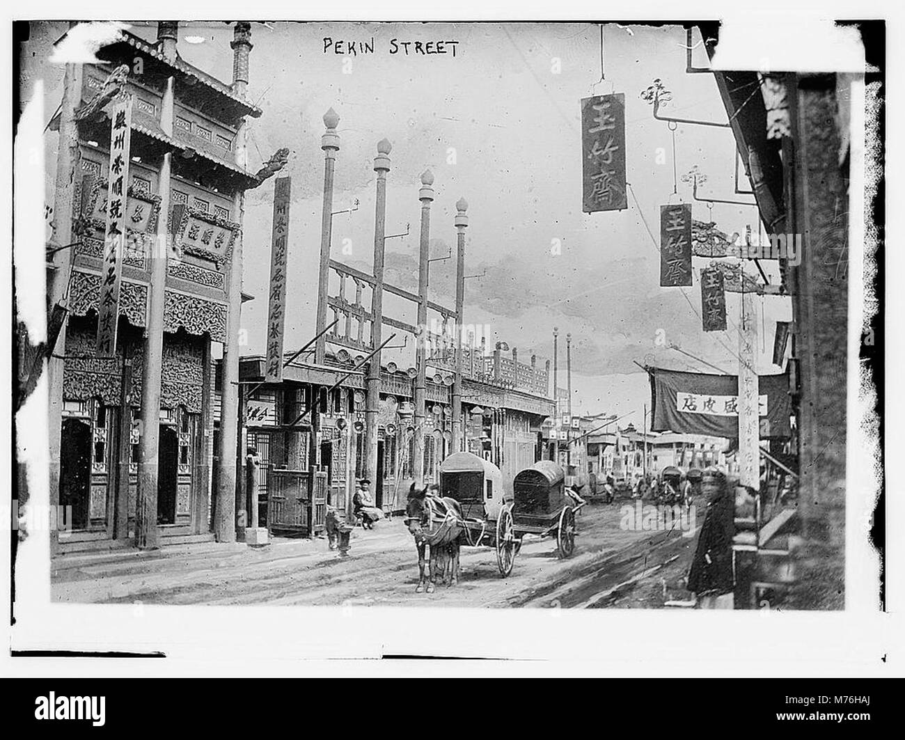 A historical photograph of a street in Peking (now Beijing), capturing ...