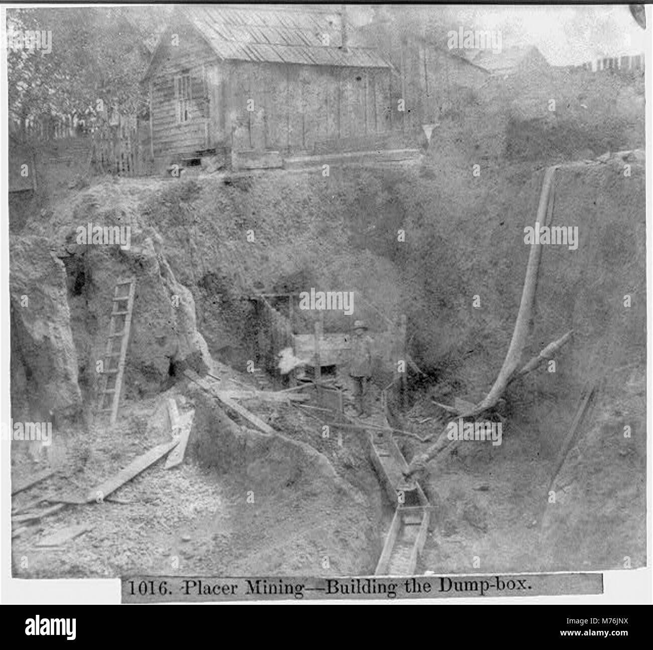 The image shows a placer mining building with a dump box, a key ...