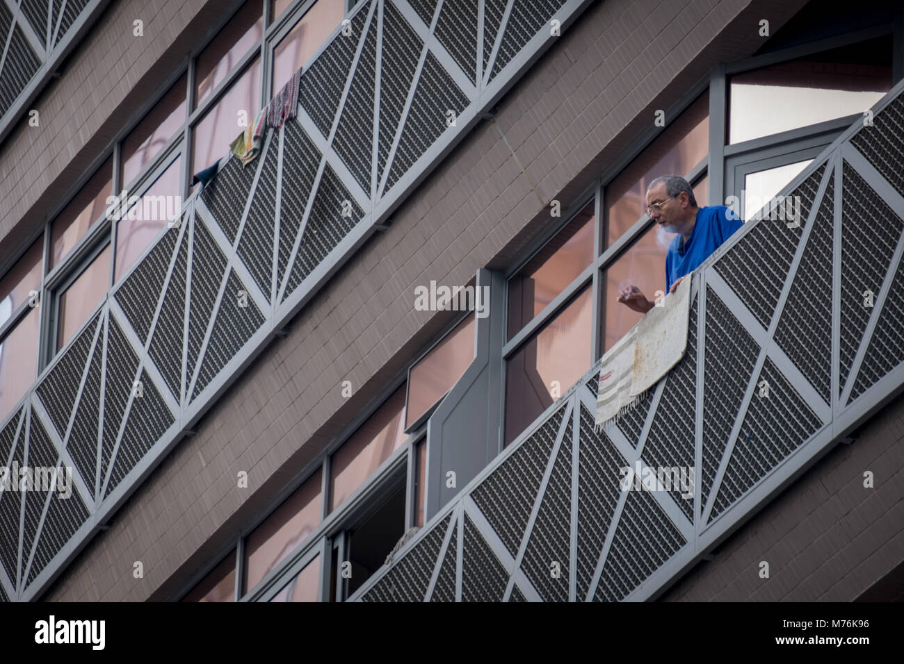 Aged man smoking at balcony of a building in Abu Dhabi Stock Photo - Alamy