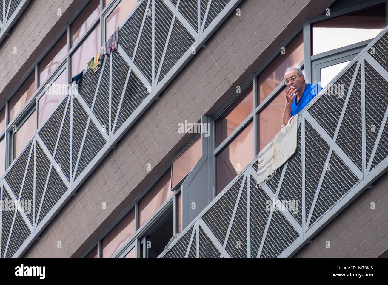 Aged man smoking at balcony of a building in Abu Dhabi Stock Photo - Alamy