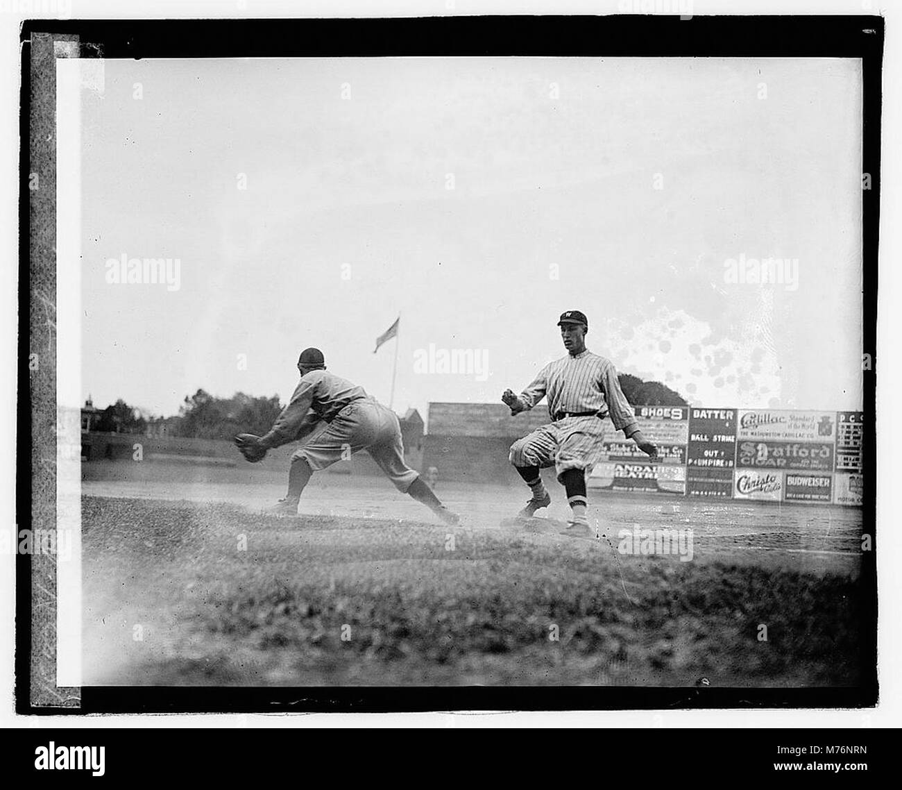 A photograph capturing a baseball play, with a runner safe on third ...
