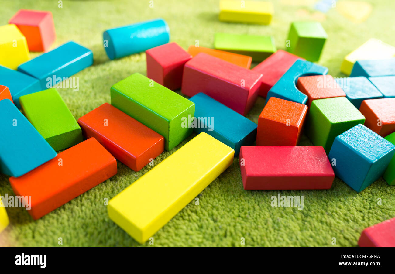 Colorful wooden blocks for children on green carpet Stock Photo - Alamy