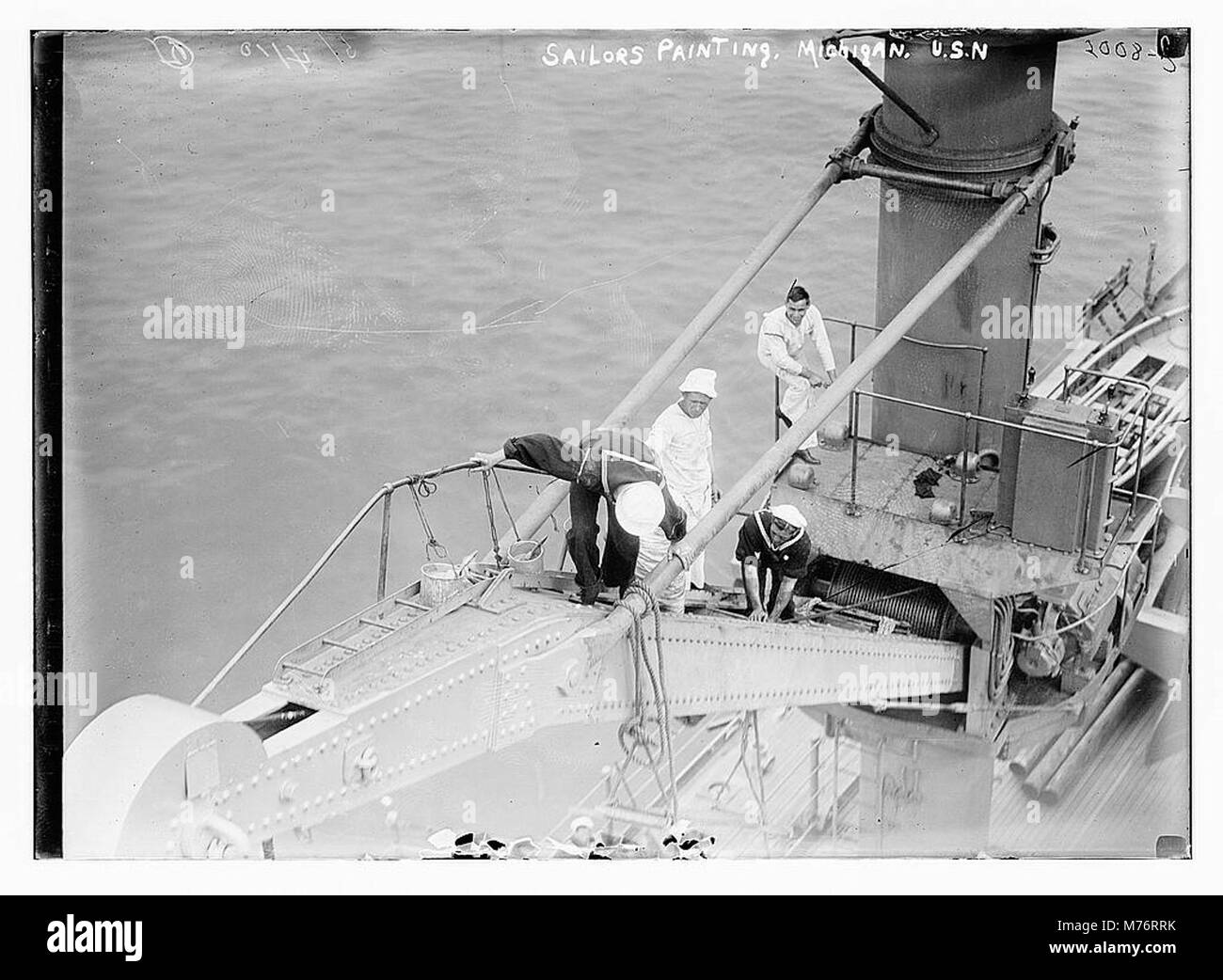 This photograph captures sailors painting the U.S.S. Michigan, a ...