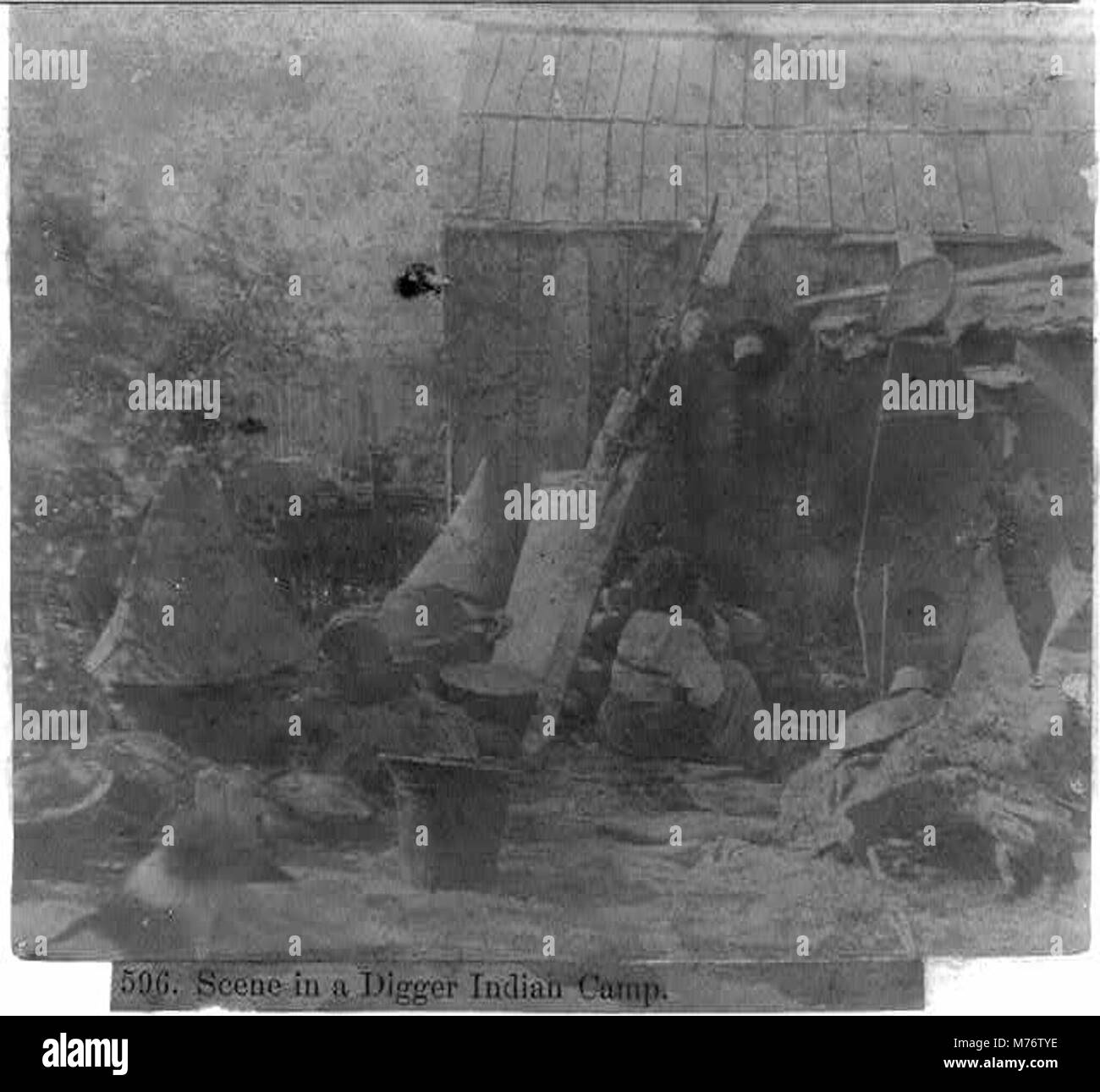 This photograph depicts a Digger Indian camp, capturing daily life and ...