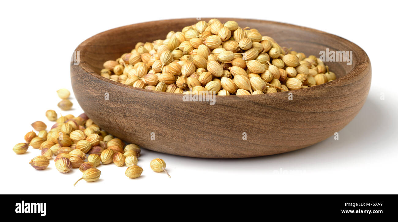 dried coriander seeds in the wooden plate, isolated on white background Stock Photo - Alamy