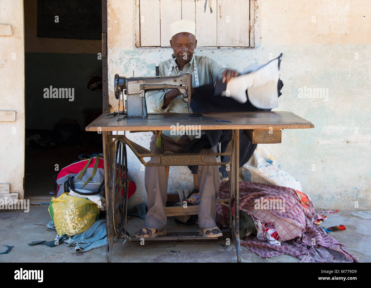 A local man making clothing with an old Singer Sewing Machine in ...